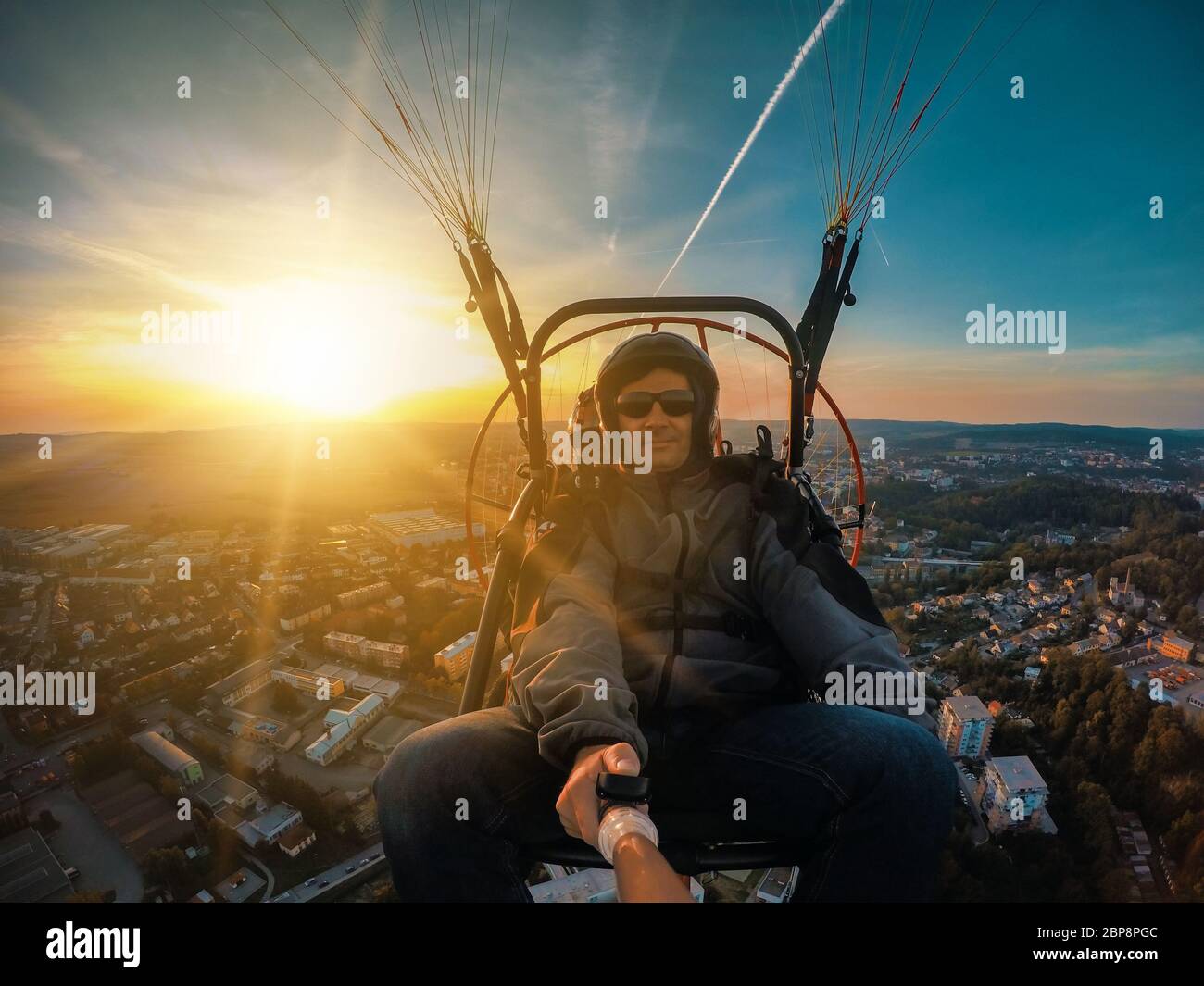 Powered paragliding tandem flight, man taking selfie with action camera ...