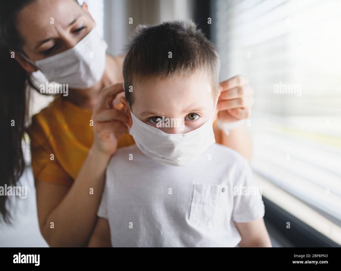 Mother and child with face masks indoors at home, Corona virus and ...