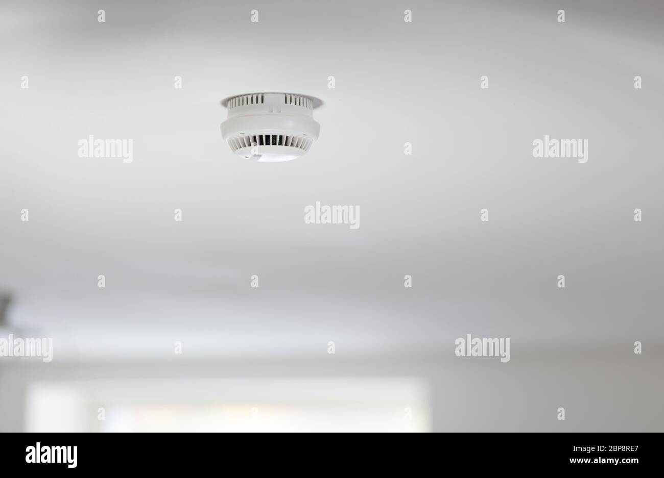 Smoke detector mounted on roof in apartment Stock Photo - Alamy