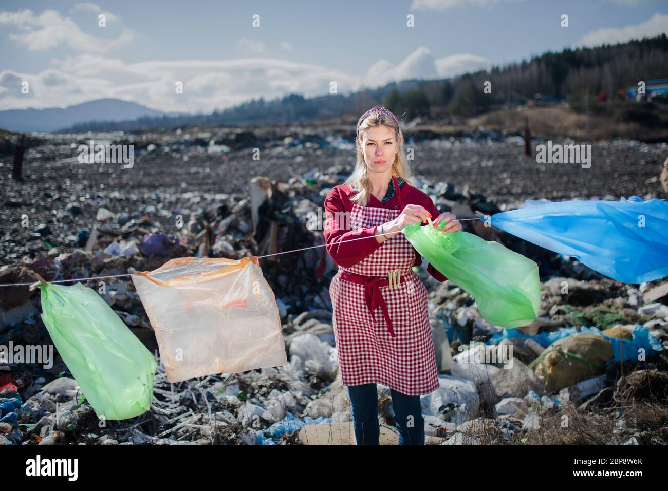 Woman on landfill, consumerism versus plastic pollution concept Stock ...