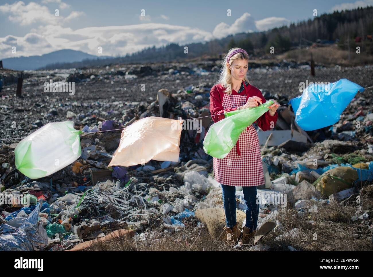 Woman on landfill, consumerism versus plastic pollution concept Stock ...