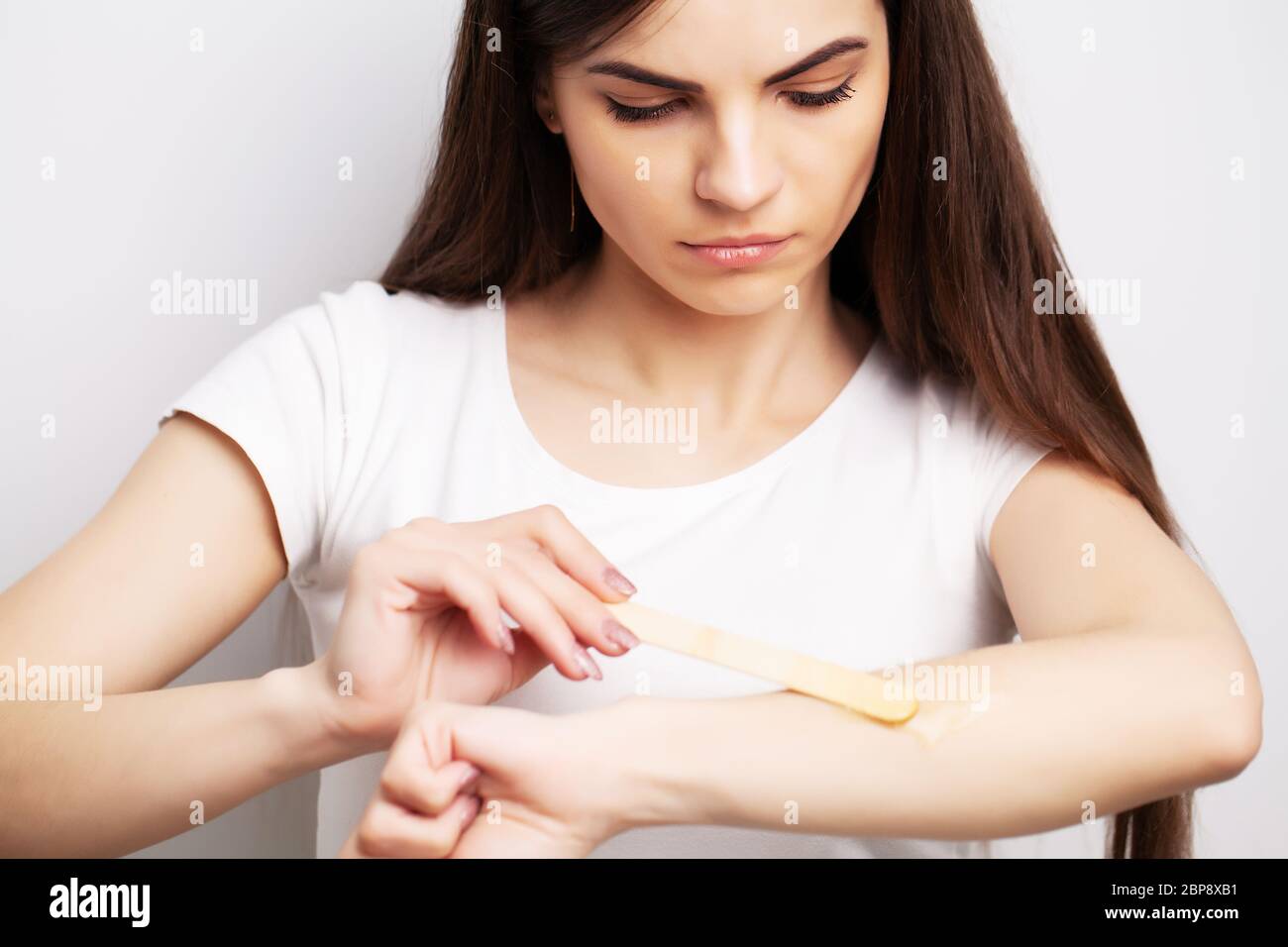 Young woman doing hair removal at home in the hands area Stock Photo ...