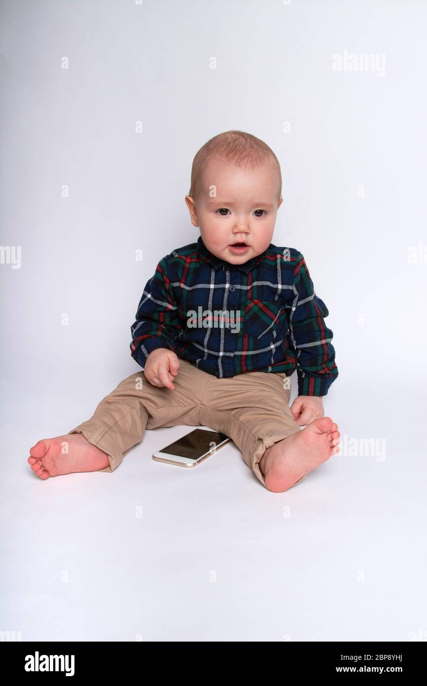 funny little boy with a phone on a white background Stock Photo - Alamy