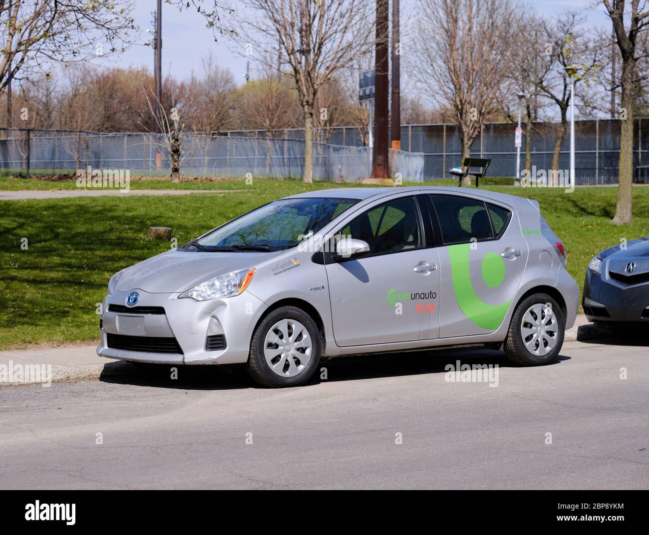 Communauto car sharing vehicle parked by a city park on the streets of ...