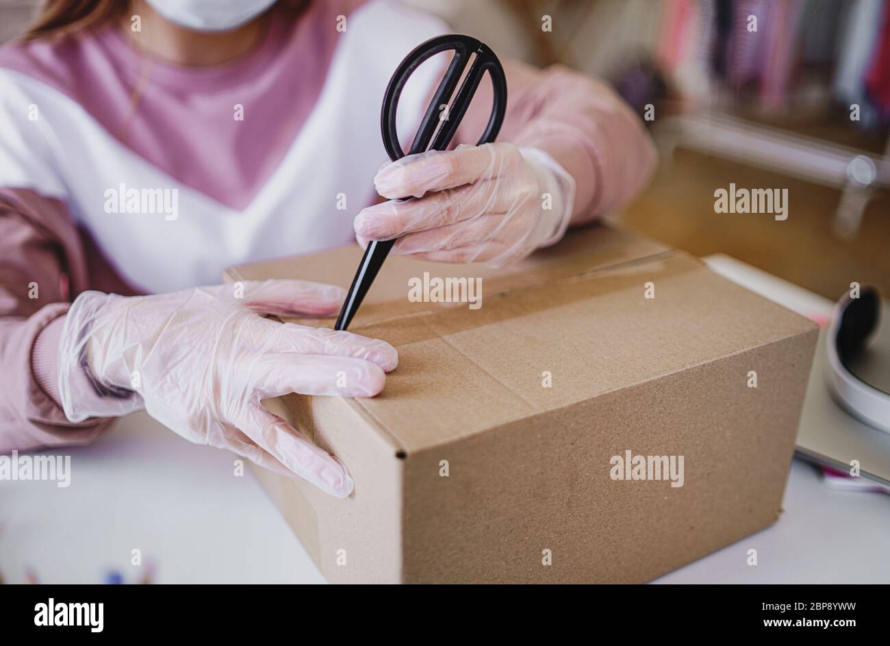 Young female student with gloves at the table, opening parcel box Stock ...