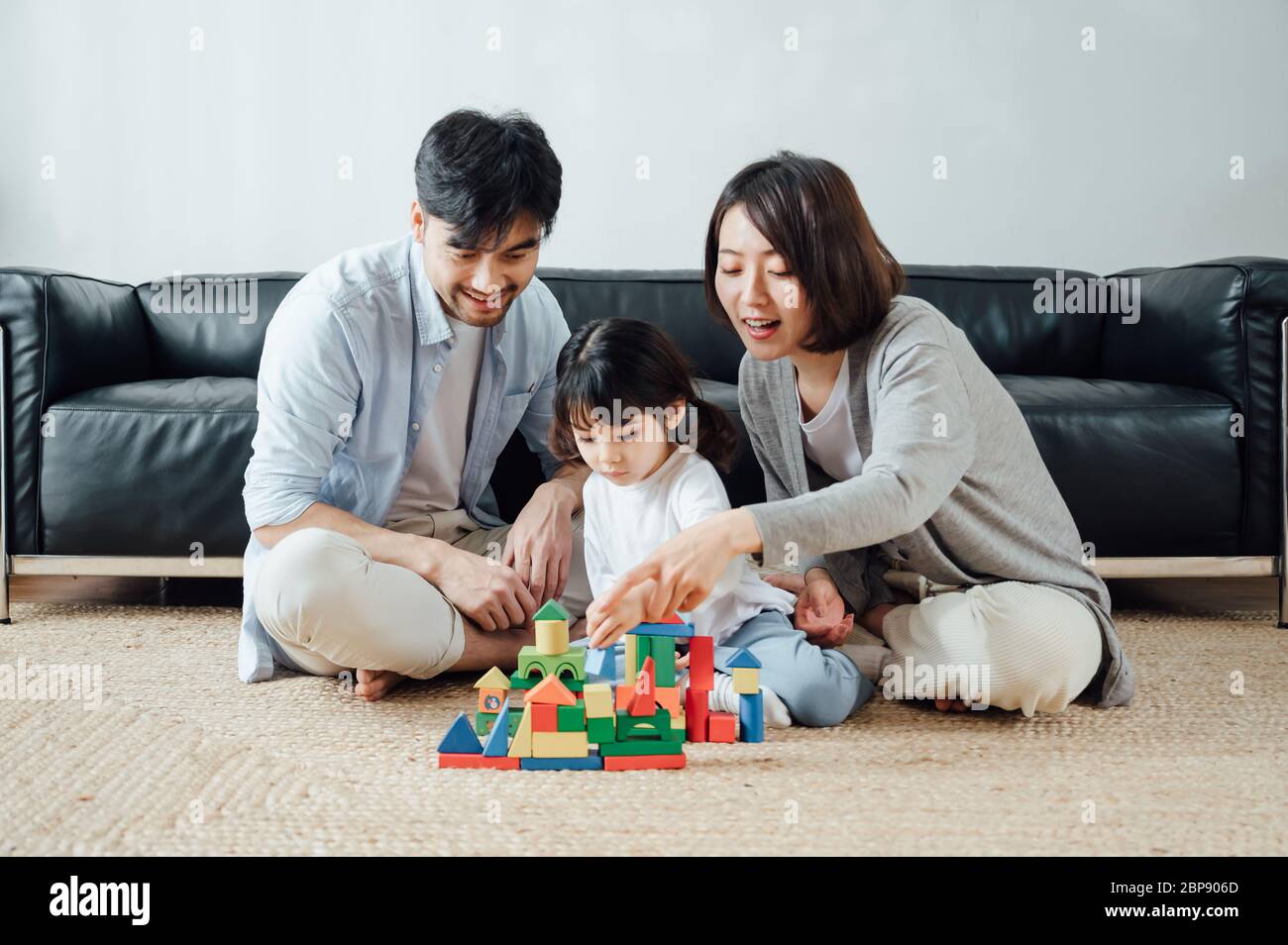 Mom and Dad and daughter at home building blocks Stock Photo - Alamy