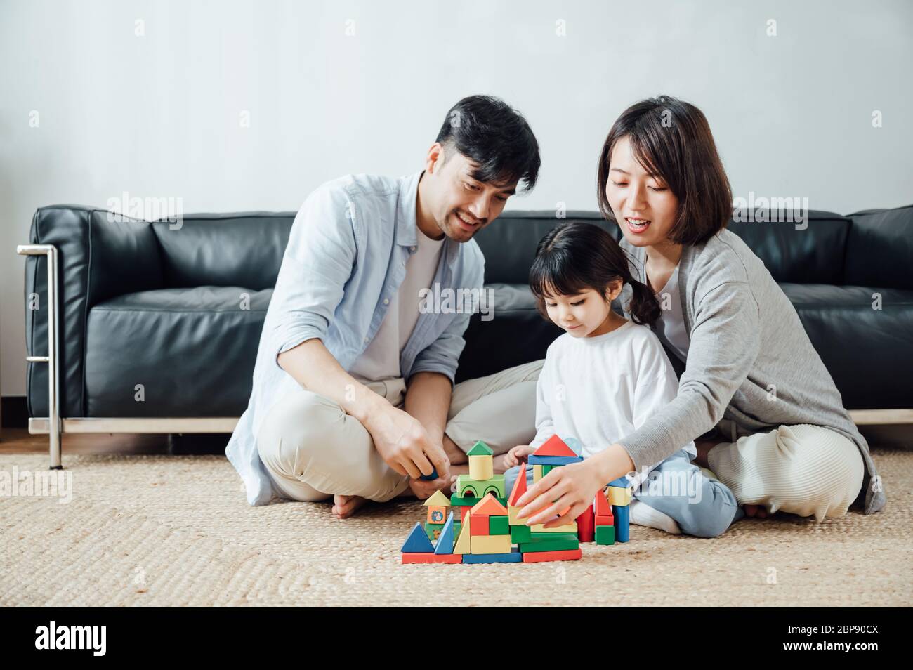 Mom and Dad and daughter at home building blocks Stock Photo - Alamy