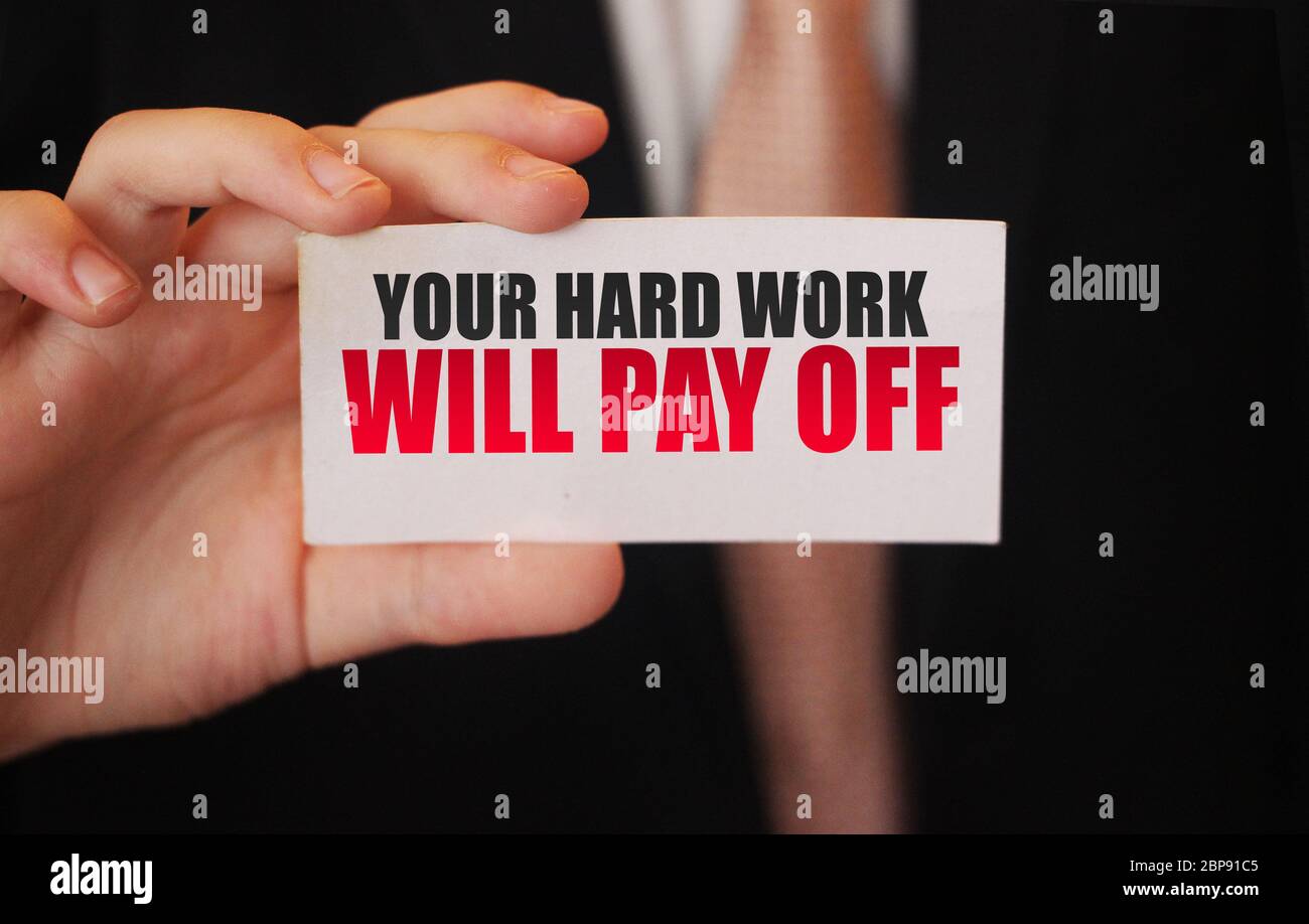 Your Hard Work Will Pay Off inspirational text on card in businessman ...