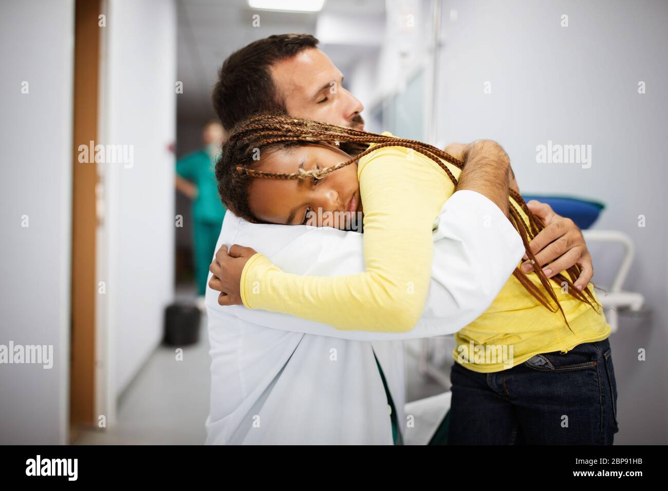 Doctor having conversation with sad little girl at the hospital. Doctor ...