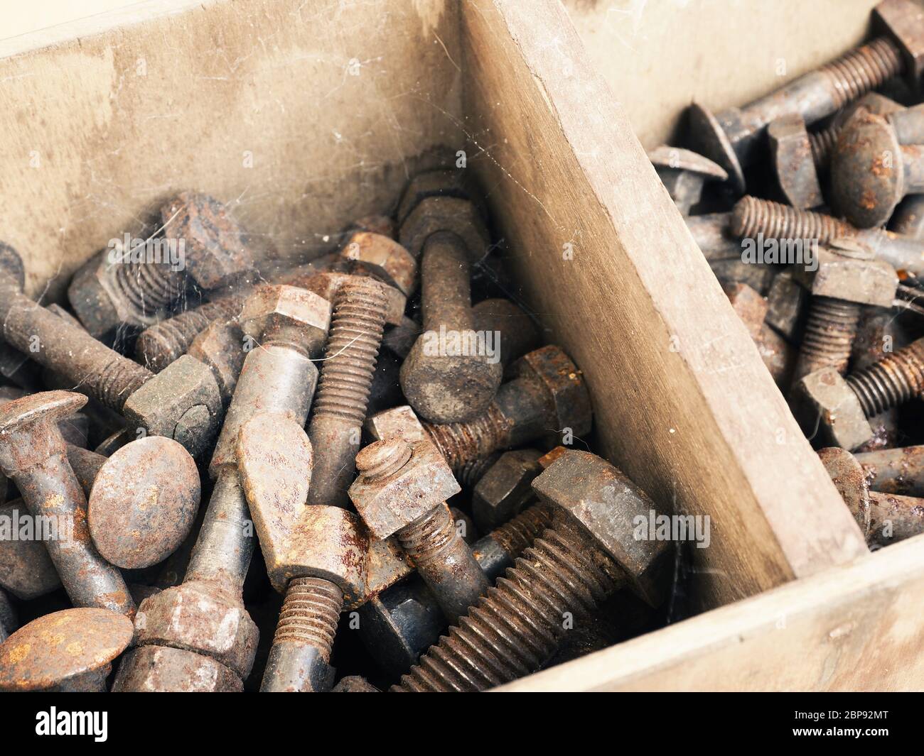 Old rusty bolts and nuts in a wooden box, industrial concept background ...