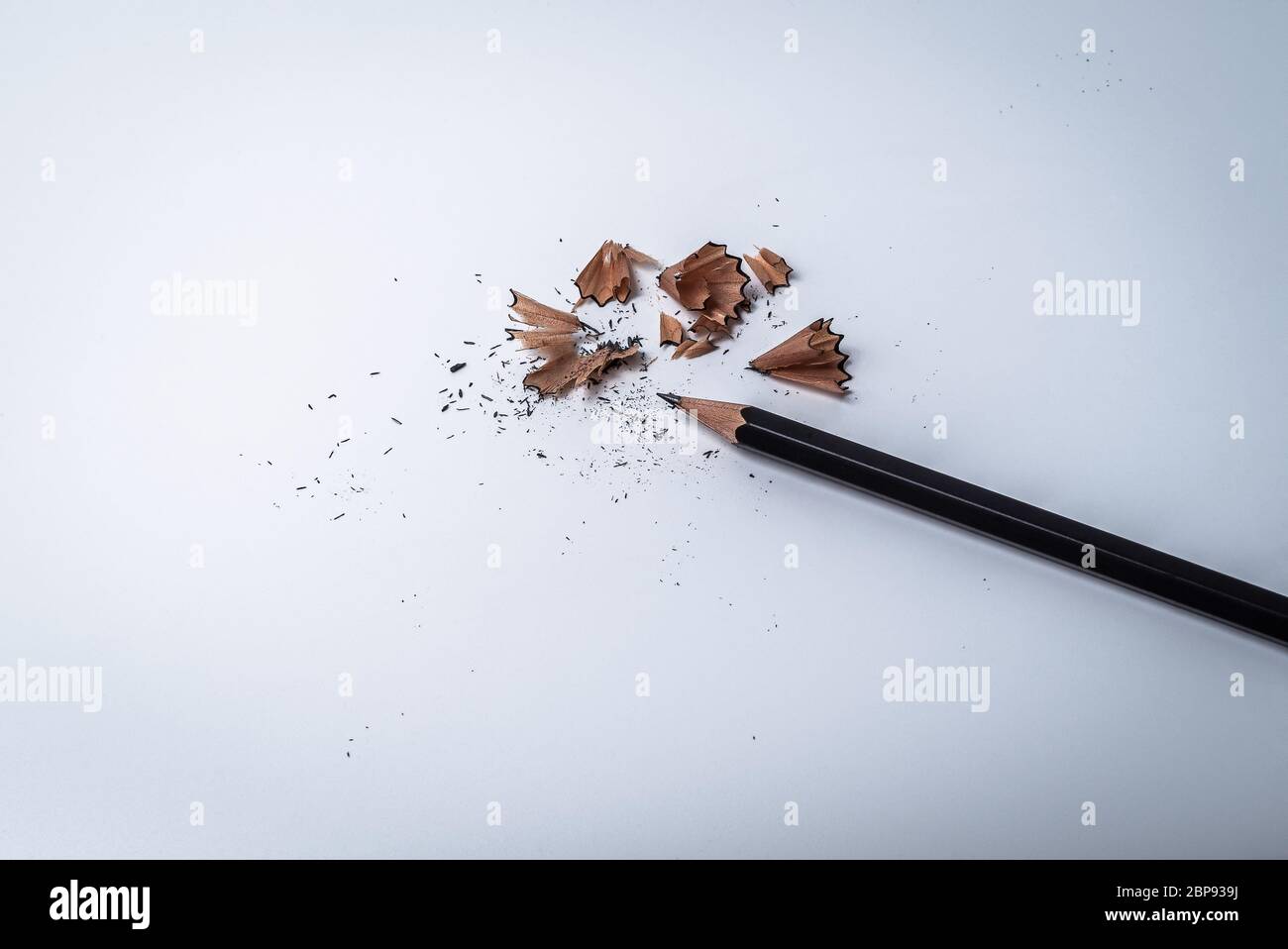 Black sharp pencil with wooden swirl shavings after sharpening with a ...