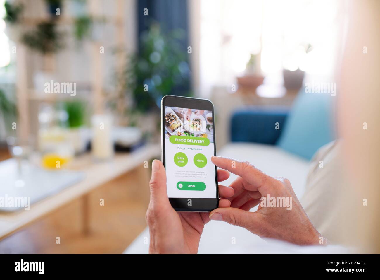 Unrecognizable woman with smartphone indoors at home, ordering food ...