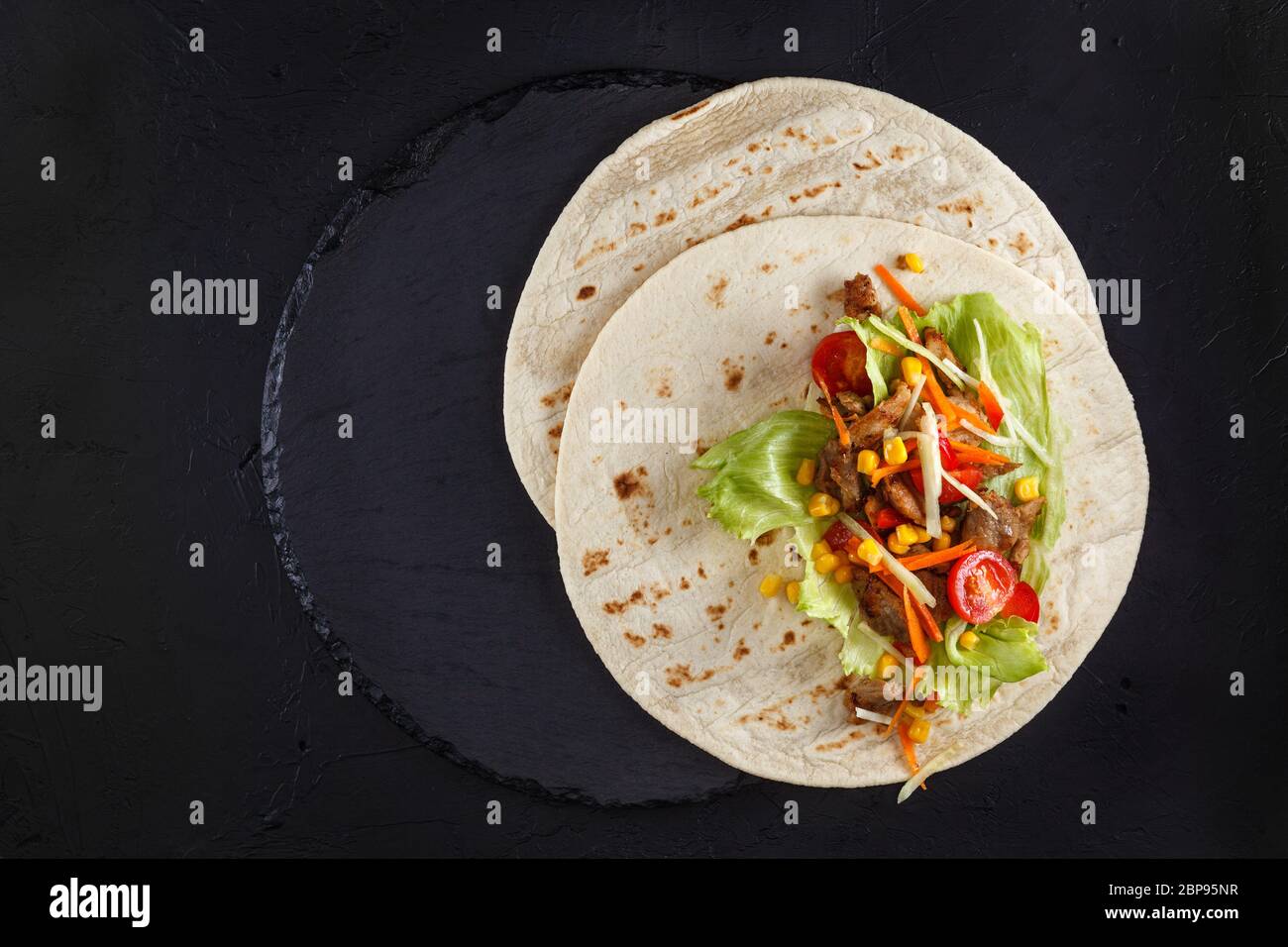 Burritos wraps with chicken and vegetables on black slate. Chicken burrito, mexican food Stock ...