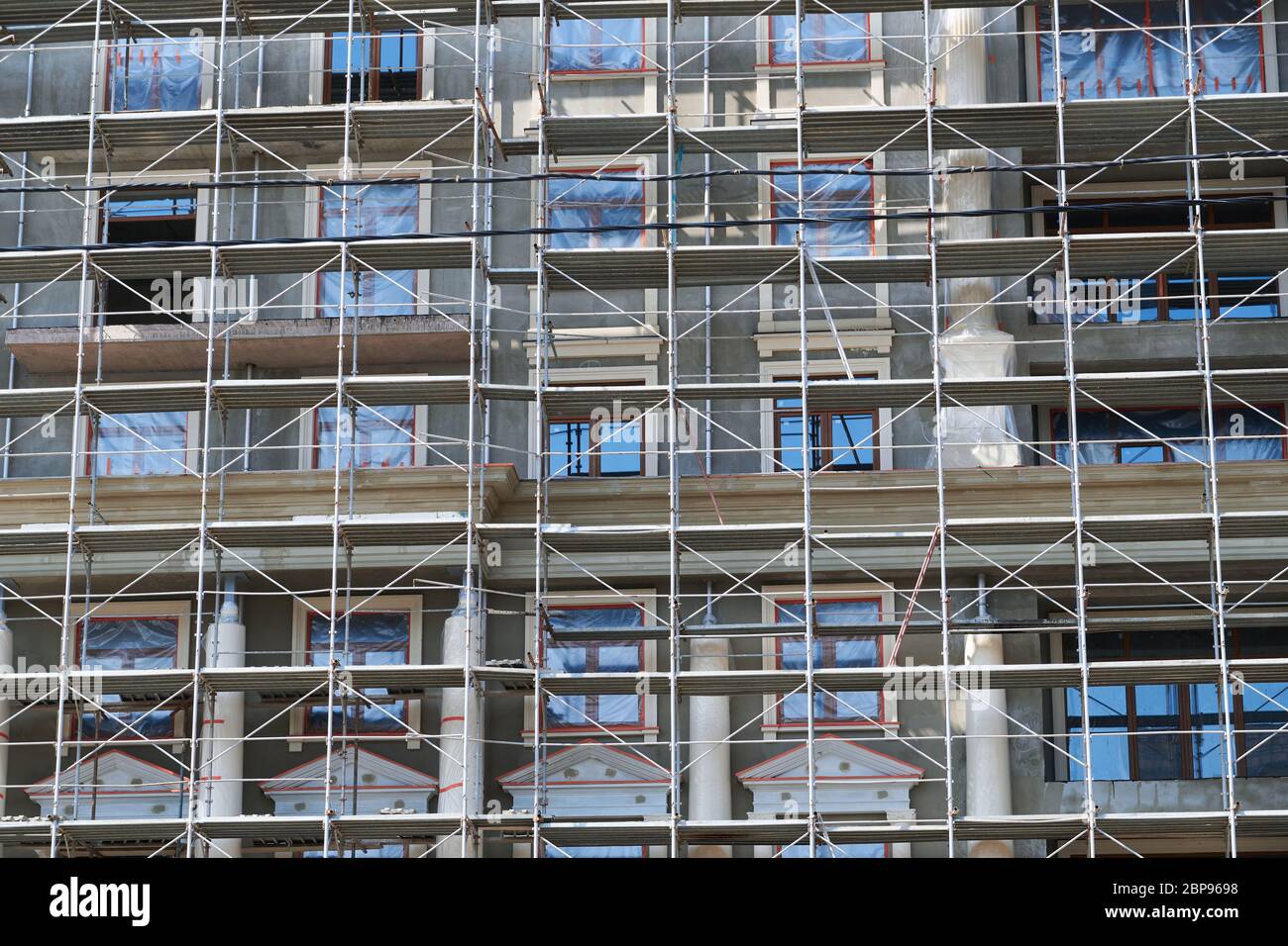 scaffolding at the facade of a building under construction, multi ...