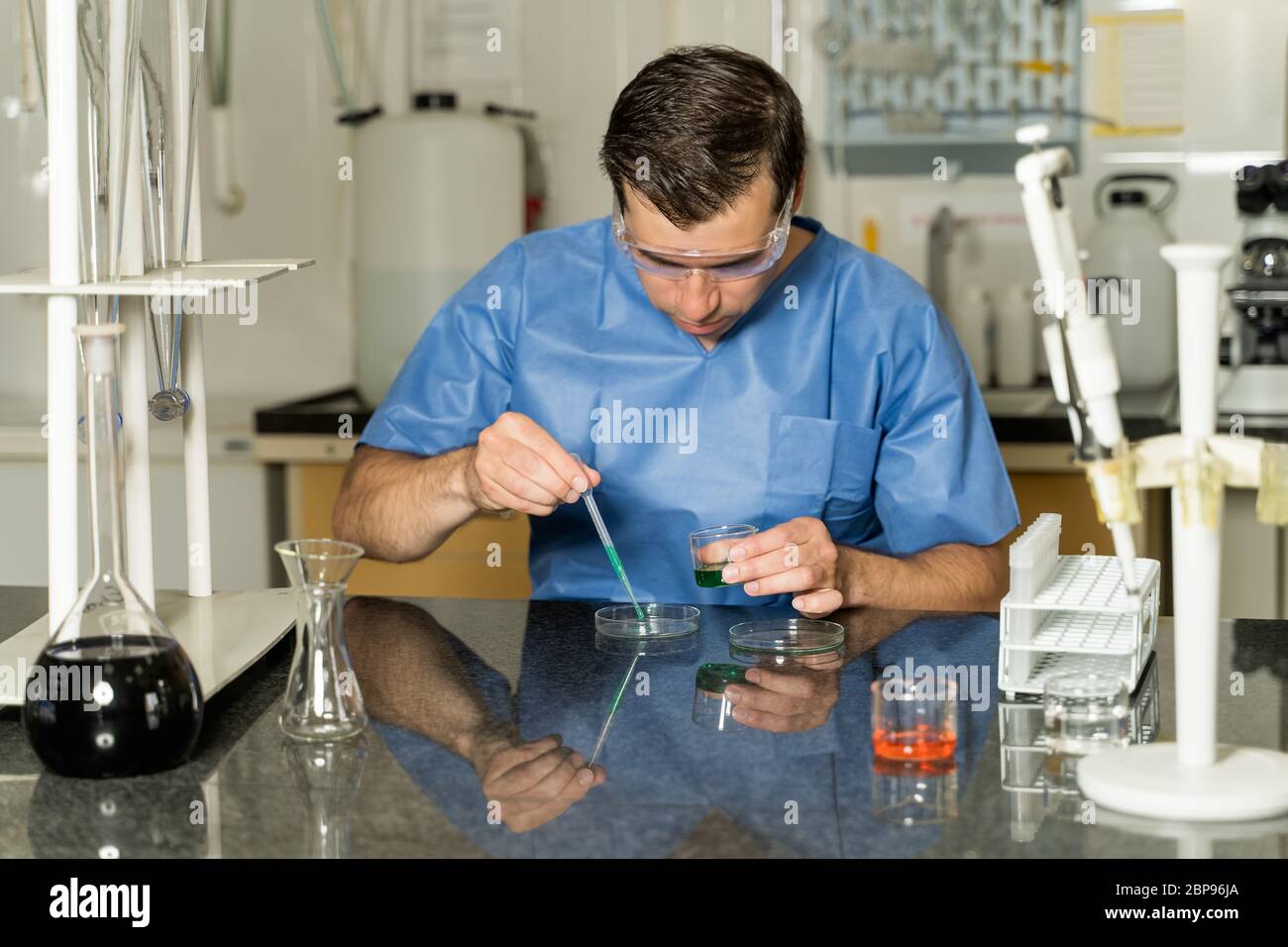 Middle age, Caucasian white, male laboratory technician in blue scrubs ...