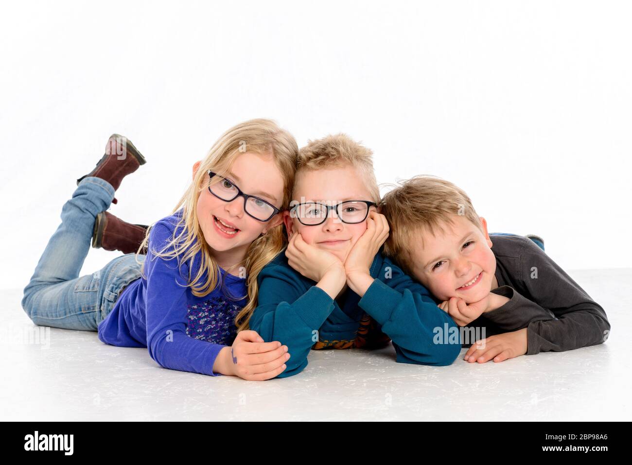 three happy children in front of white background Stock Photo - Alamy