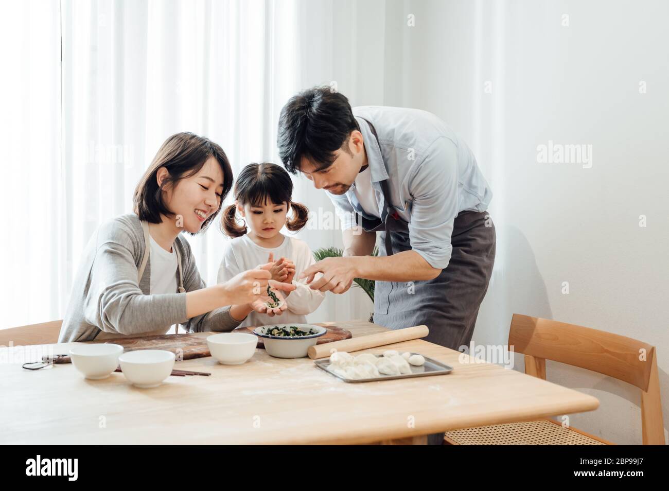 Mom and Dad and daughter at home dumplings Stock Photo - Alamy