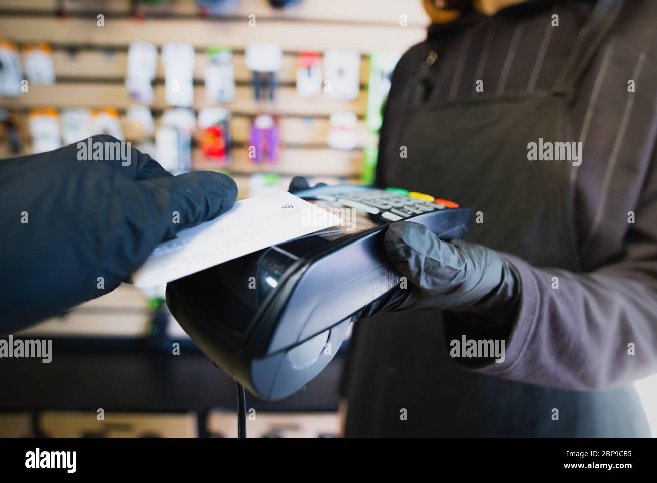 Paying with a credit card at a small local shop. Store assistant ...