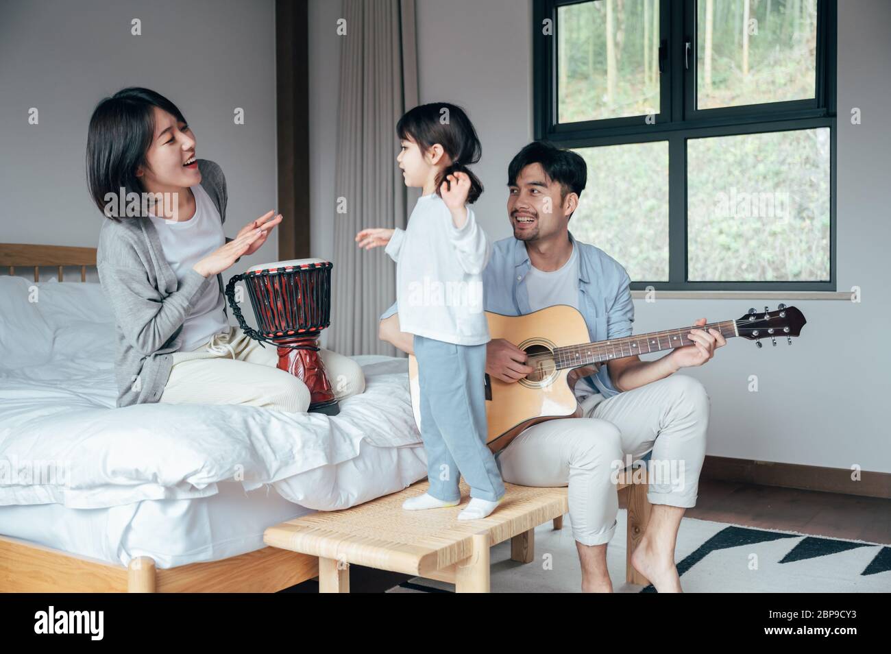 Mom and Dad and daughter sing at home Stock Photo - Alamy