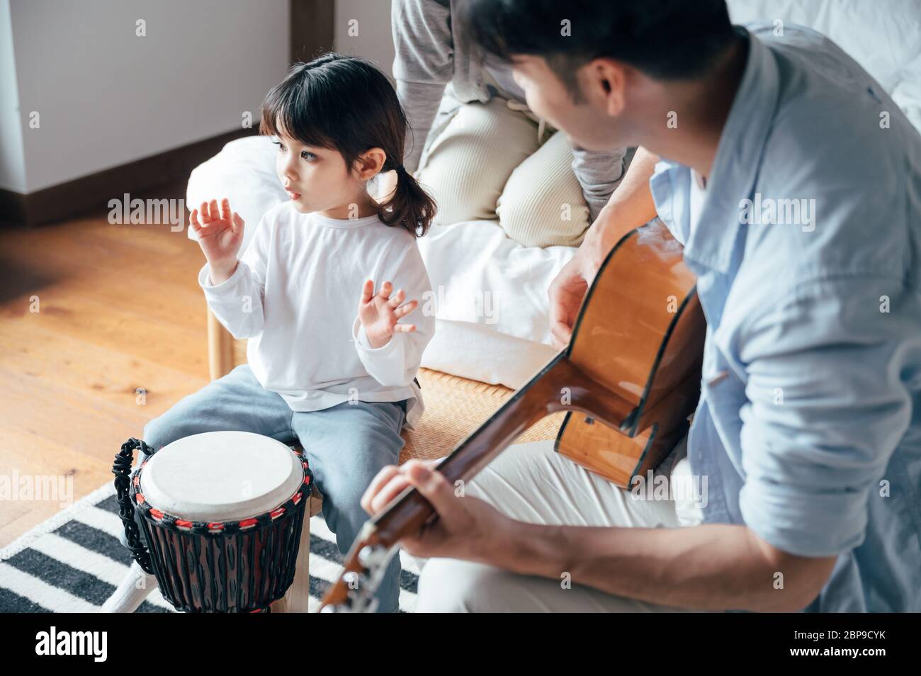 Mom and Dad and daughter sing at home Stock Photo - Alamy
