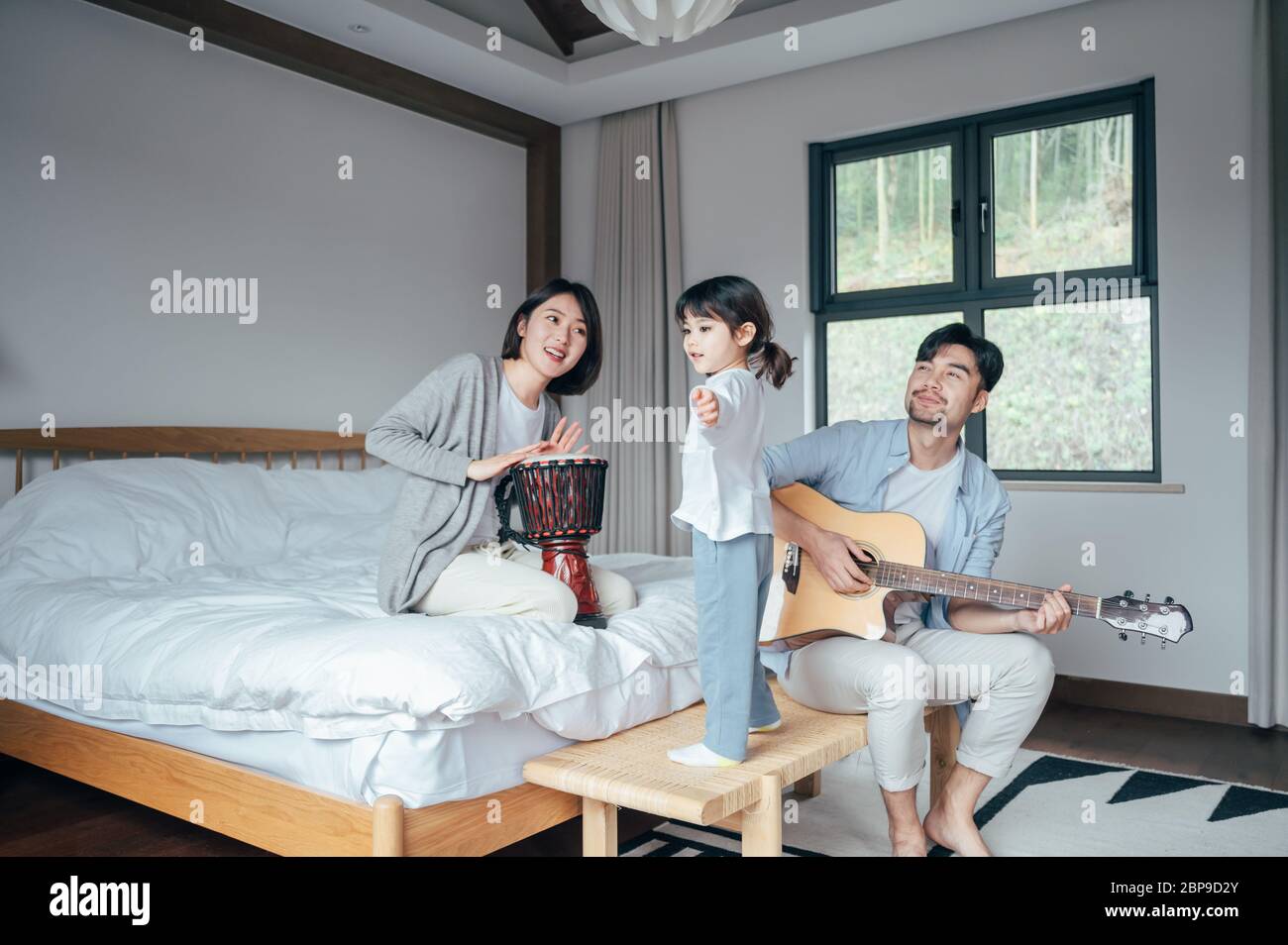 Mom and Dad and daughter sing at home Stock Photo - Alamy