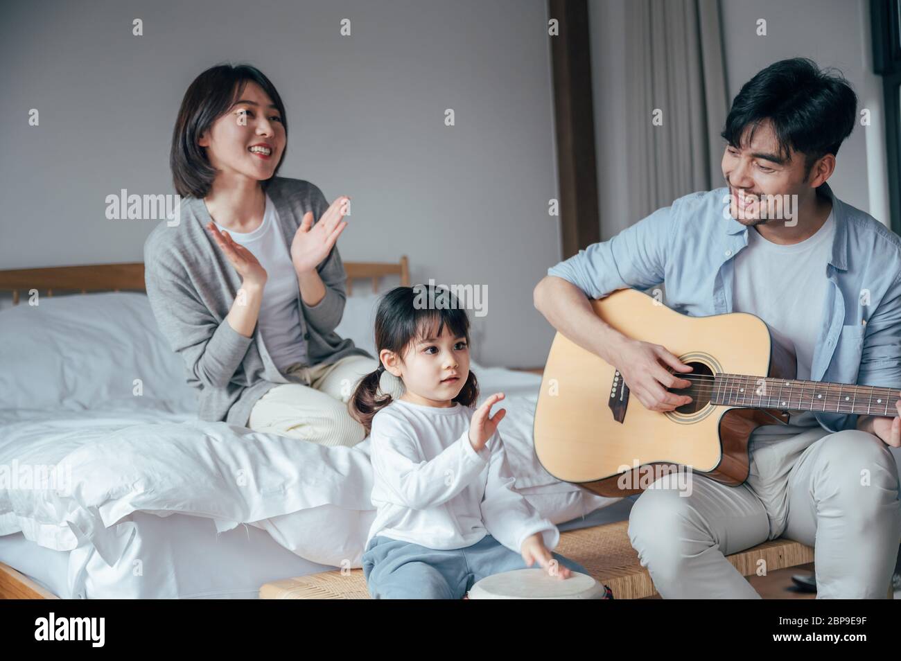 Mom and Dad and daughter sing at home Stock Photo - Alamy