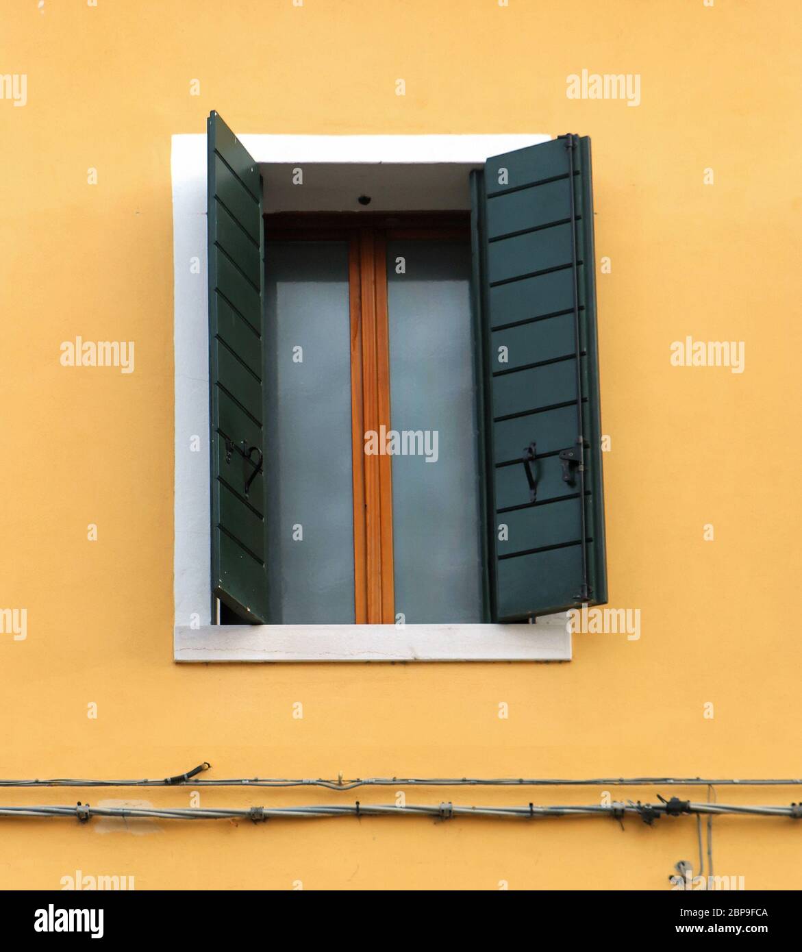 Open window exterior with wooden shades on retro house with yellow ...