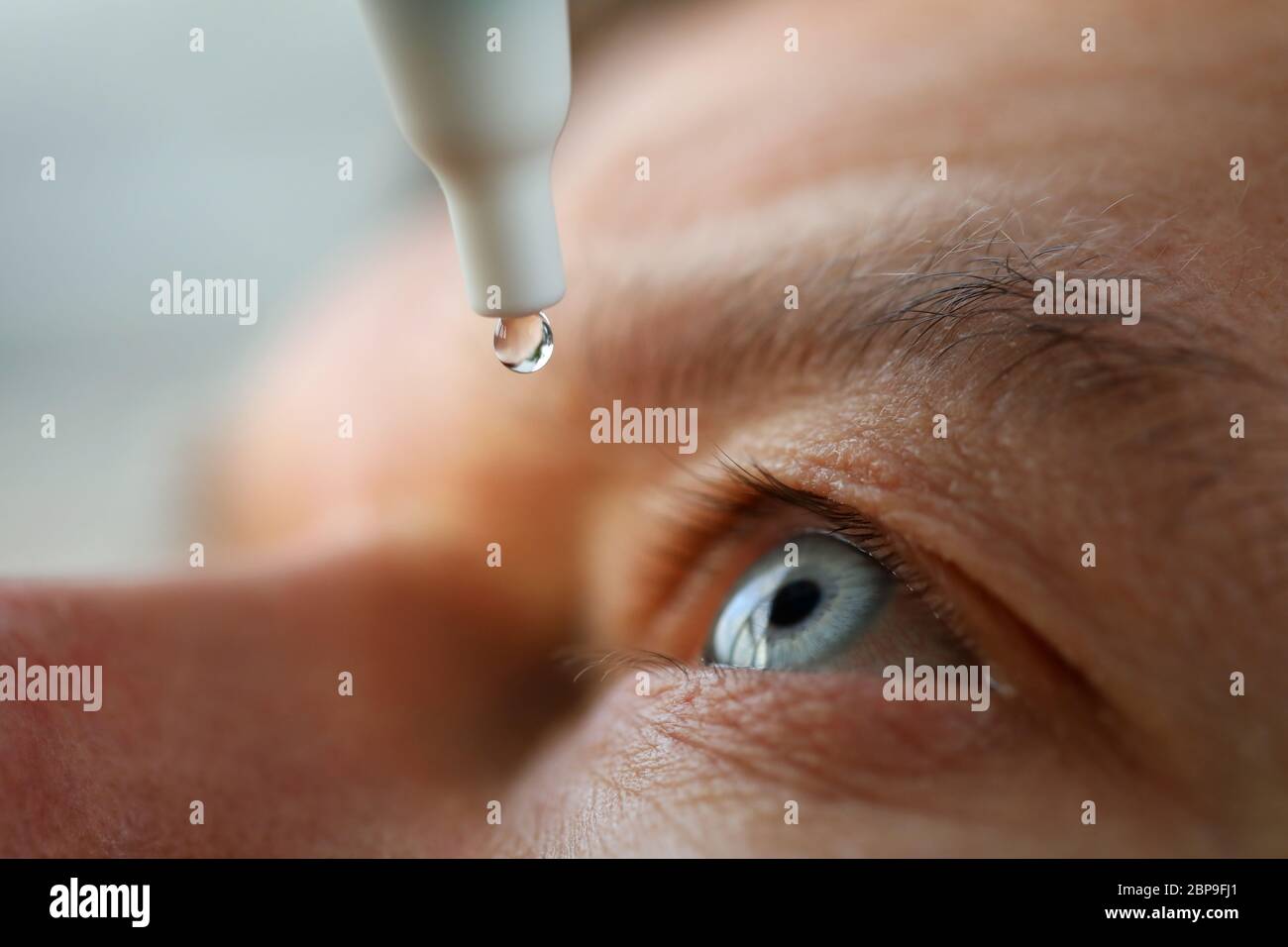 Man drops eye drops install lenses, moisturizing Stock Photo - Alamy