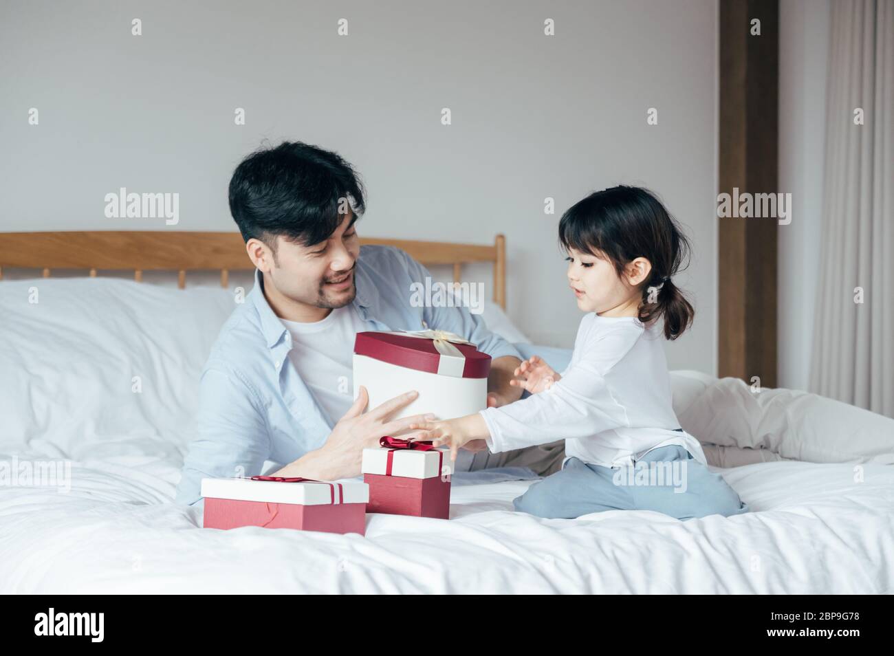 Father and daughter at home opening presents Stock Photo - Alamy