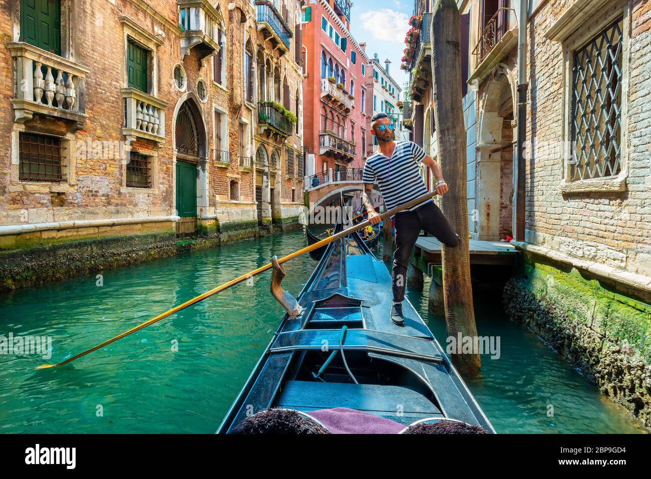 Handsome gondolier during gondola ride on the street of Venice, Italy ...