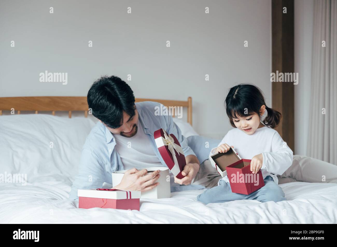Father and daughter at home opening presents Stock Photo - Alamy