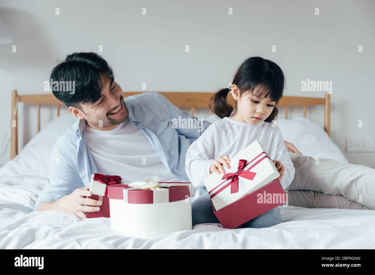Father and daughter at home opening presents Stock Photo - Alamy