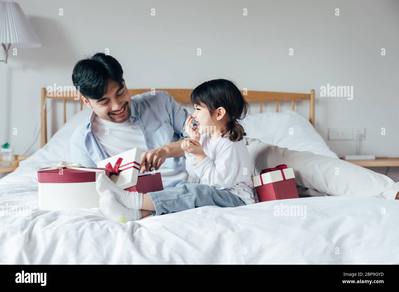 Father and daughter at home opening presents Stock Photo - Alamy