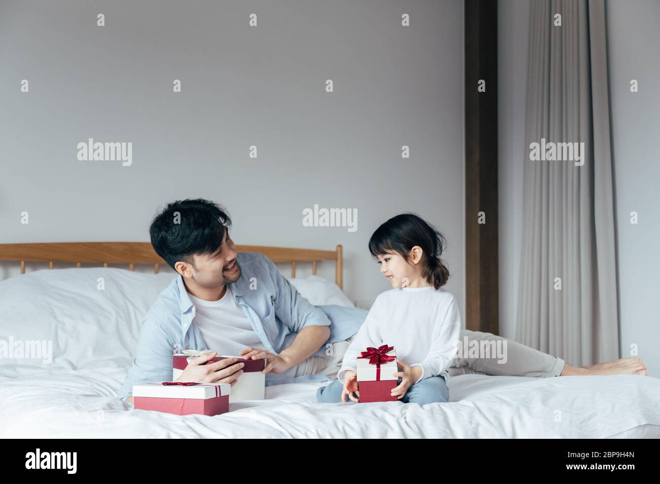 Father and daughter at home opening presents Stock Photo - Alamy