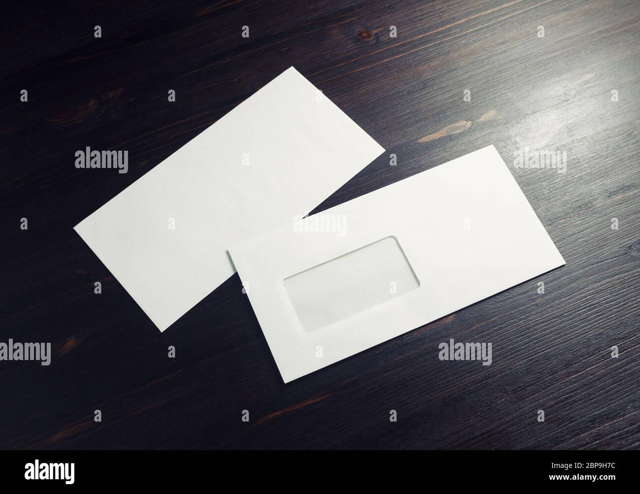 Blank envelopes with window on dark wooden background. Front and back ...