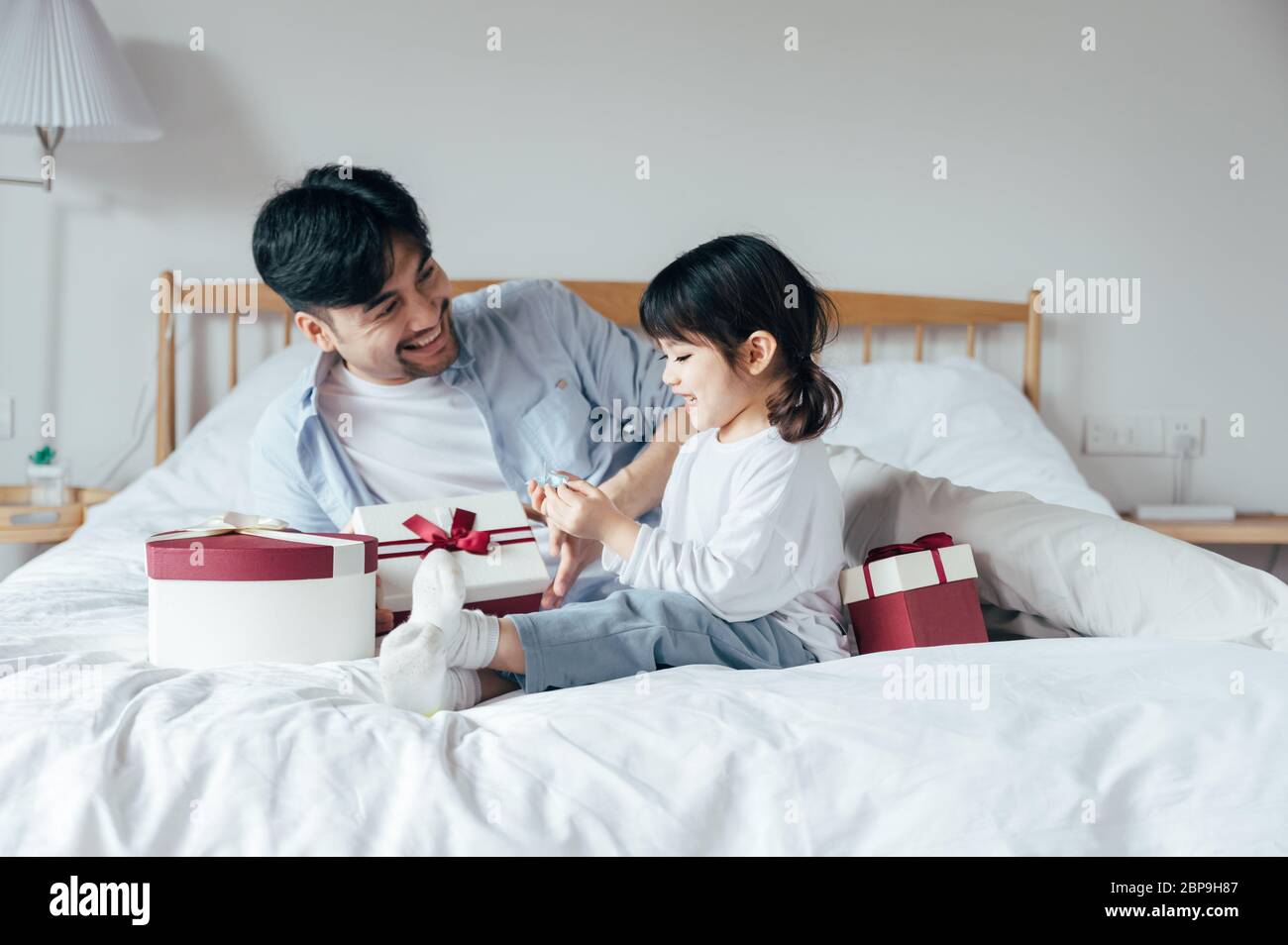 Father and daughter at home opening presents Stock Photo - Alamy