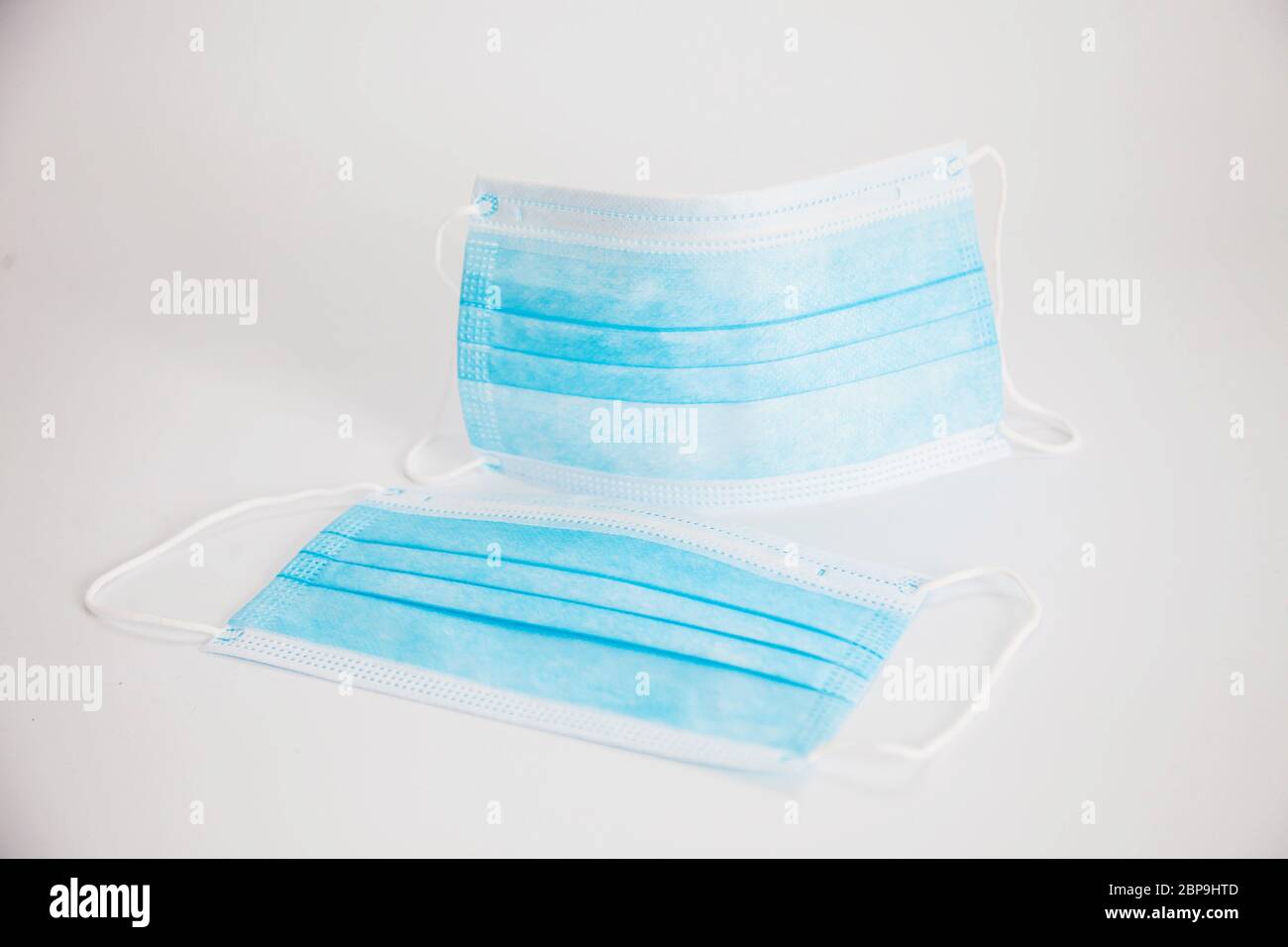 Blue protective medical masks lie on a white background Stock Photo - Alamy