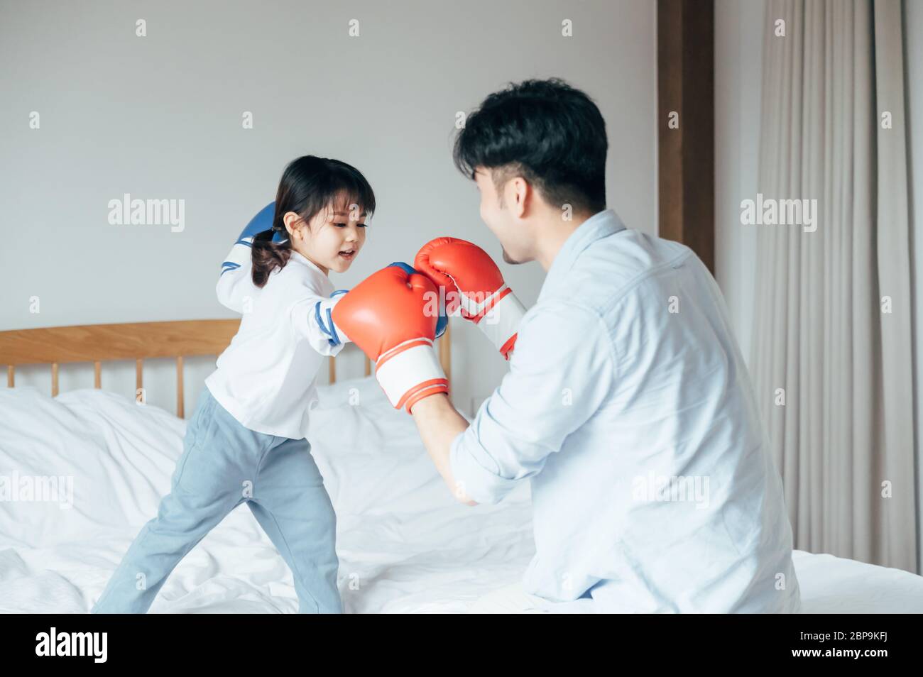 Dad and daughter playing in bed Boxing Stock Photo - Alamy