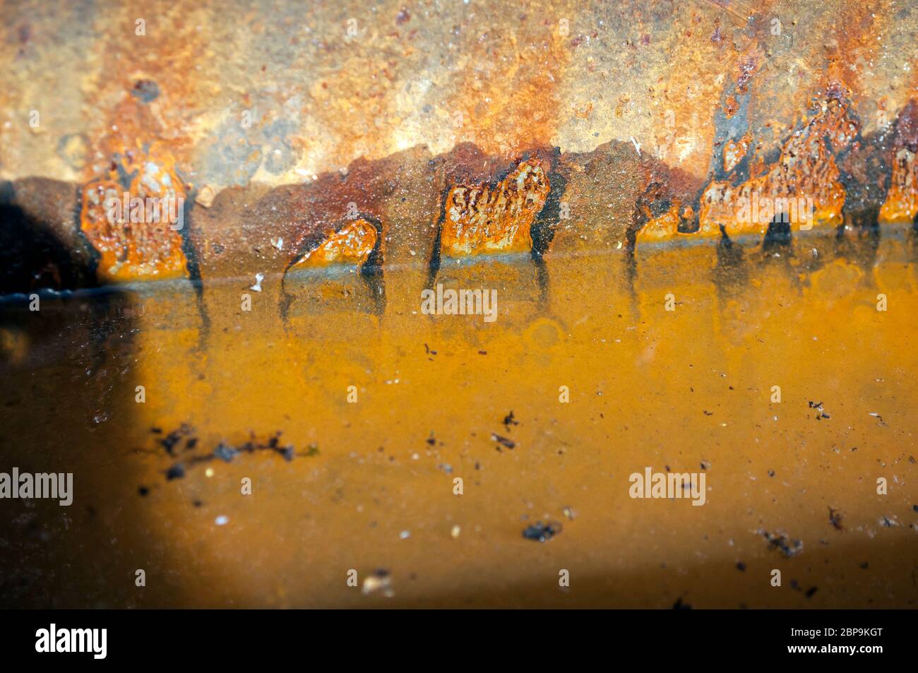 Rusty round iron tank, barrel, half filled with water. You can see rust ...