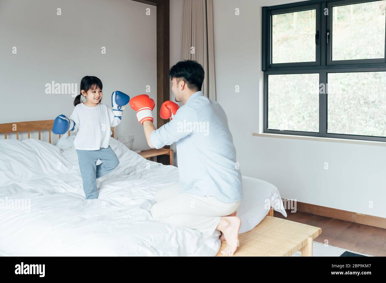 Dad and daughter playing in bed Boxing Stock Photo - Alamy