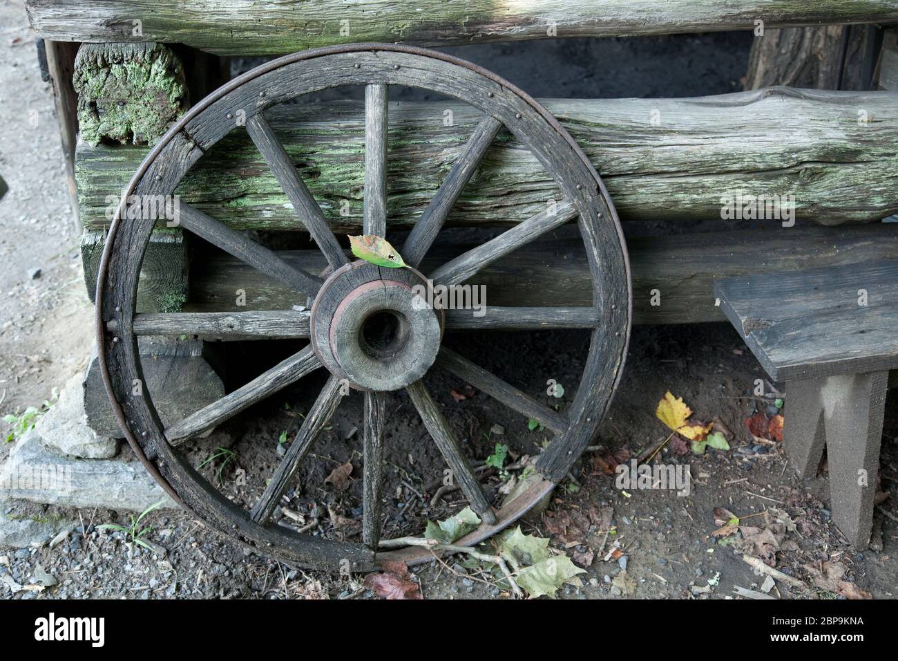 Old wheel against log cabin wall Stock Photo - Alamy
