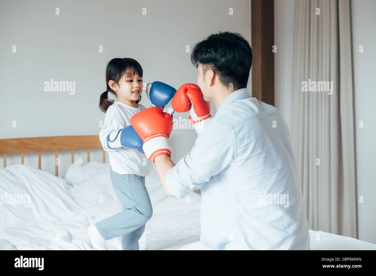 Dad and daughter playing in bed Boxing Stock Photo - Alamy