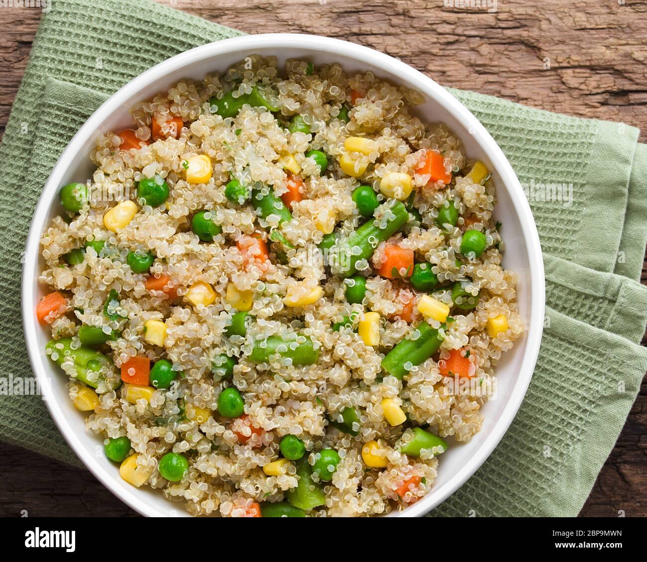 Fresh homemade cooked white quinoa with colorful vegetables (green peas ...