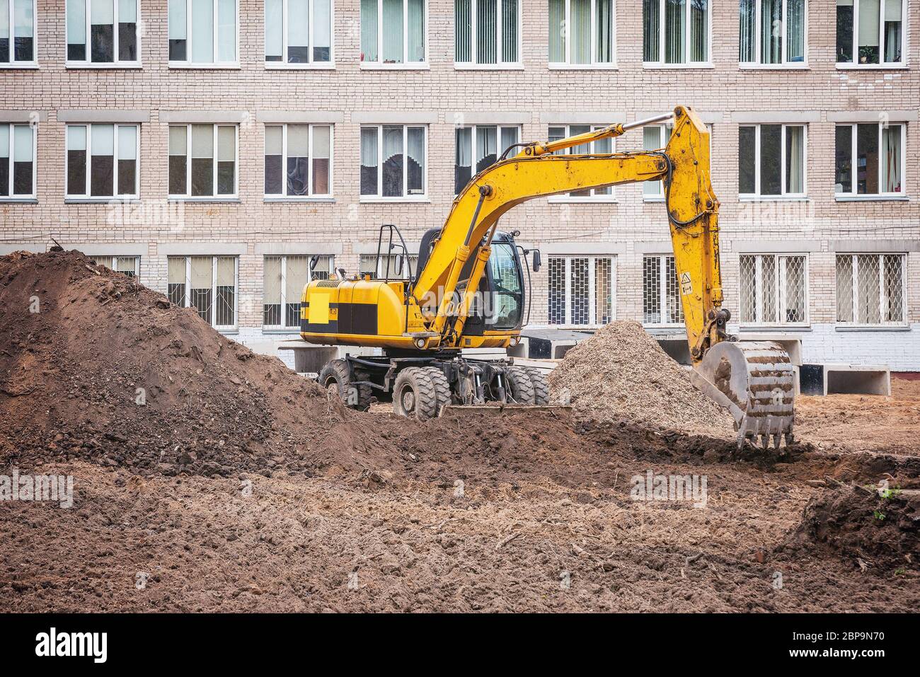 Excavator digs a hole on the construction site territory Stock Photo ...