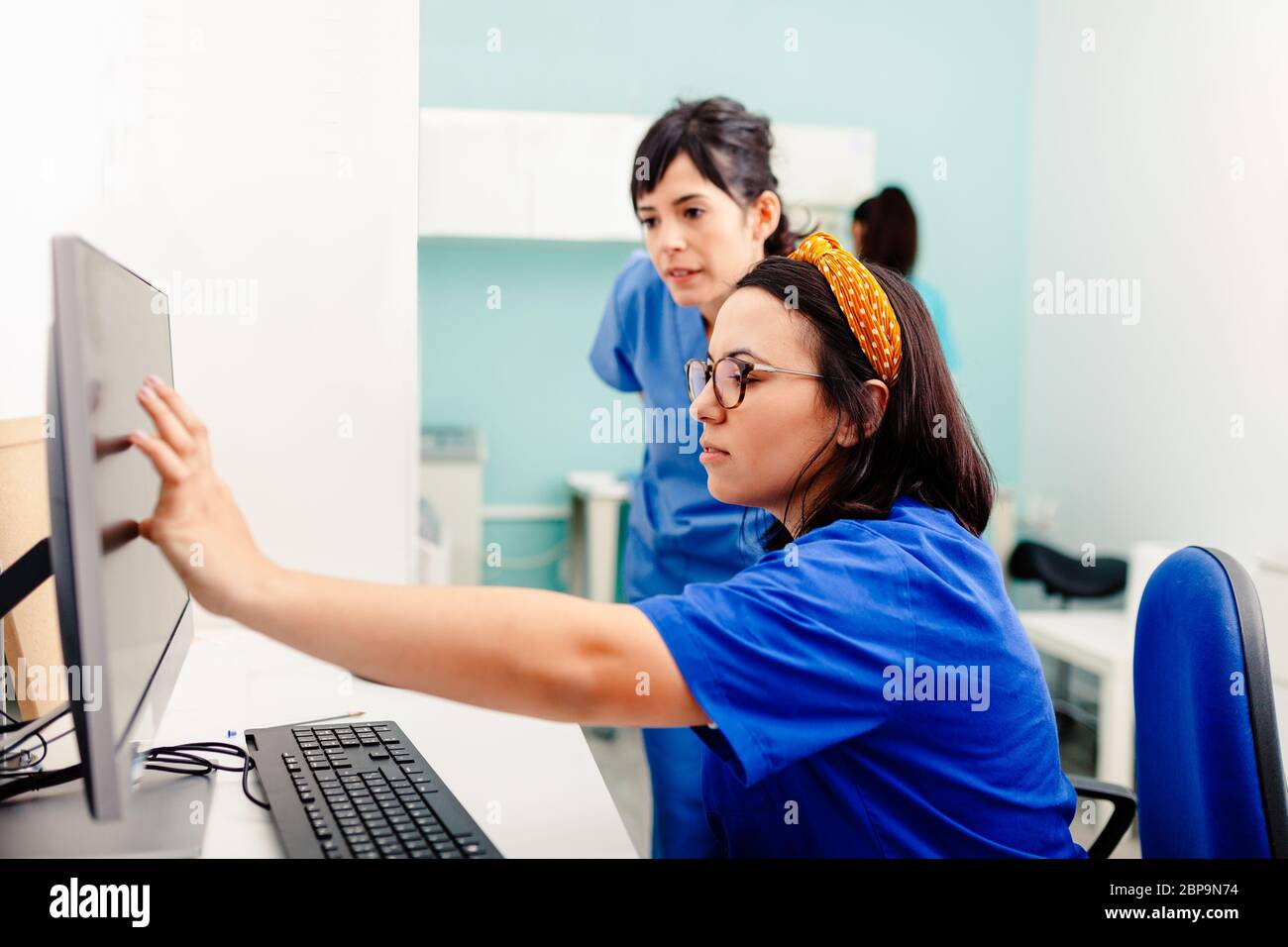 Two nurses using a computer in a x-ray room Stock Photo - Alamy