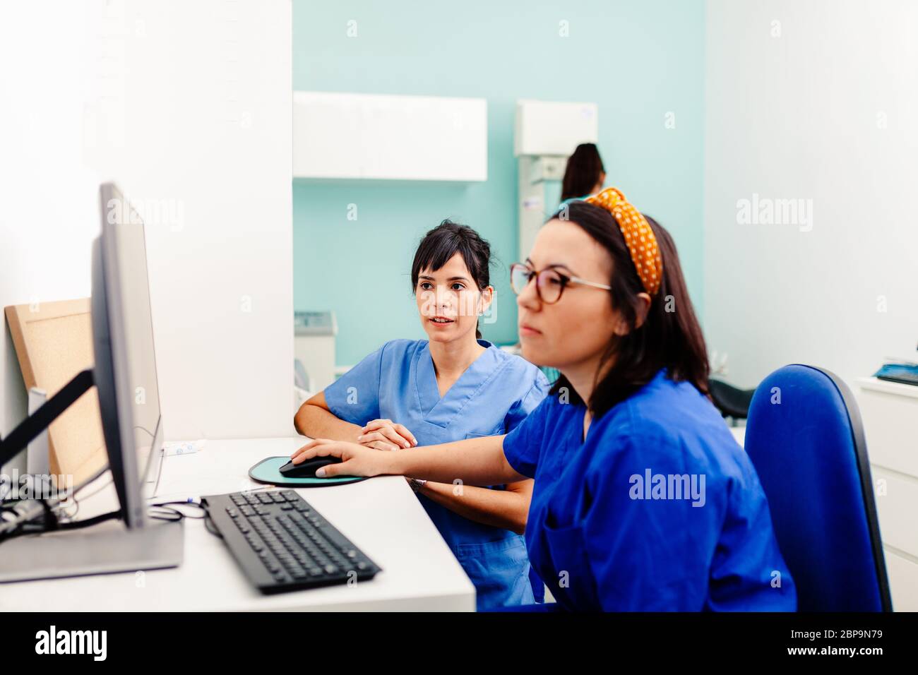 Two nurses using a computer in a x-ray room Stock Photo - Alamy
