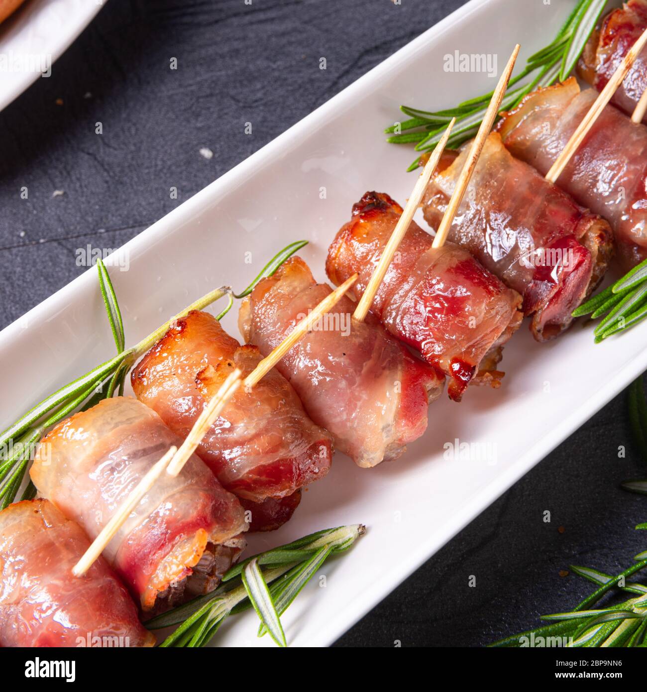 dates wrapped in bacon and delicious tapas Stock Photo - Alamy