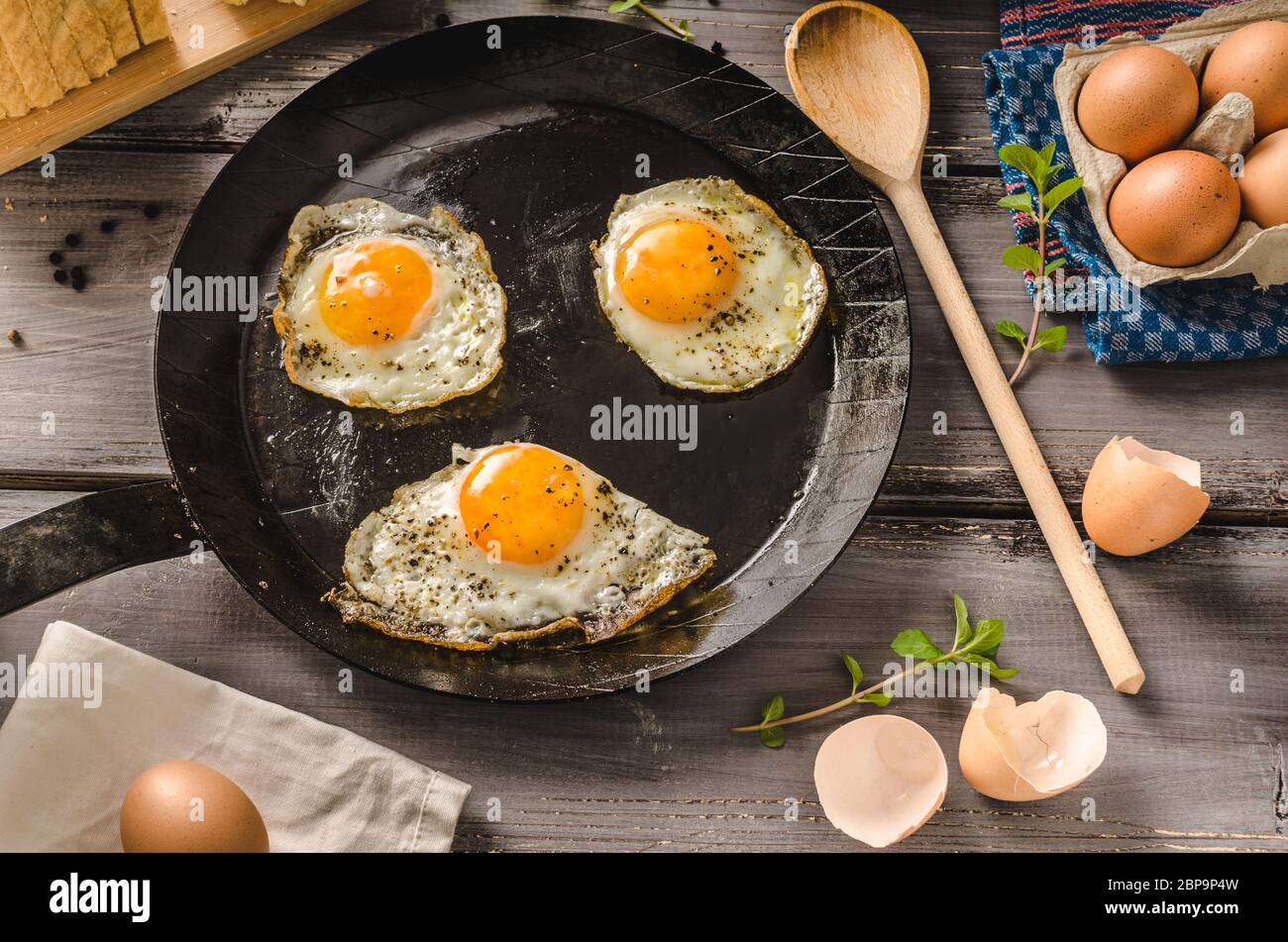 Eggs fried rustic style, bio eggs with white bread Stock Photo - Alamy