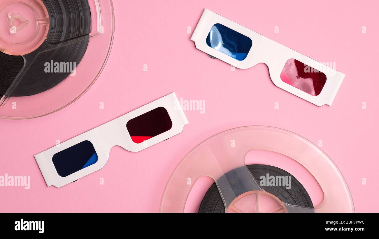 Cardboard 3d glasses and reels of film on pink background. Watching ...
