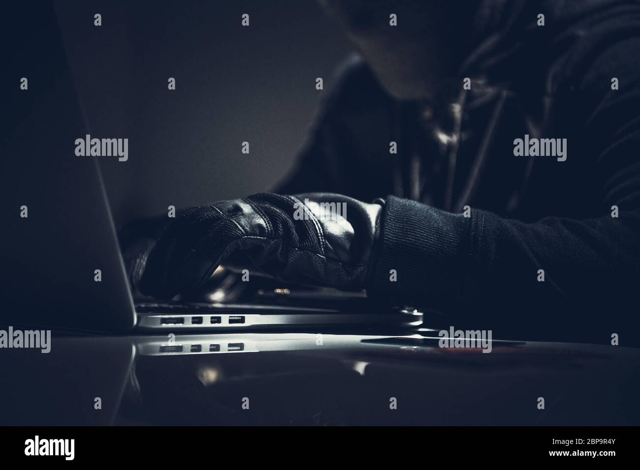 Masked Male Hacker Sitting In Dark Room At Laptop Computer Committing ...